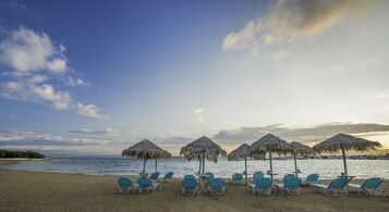Uma praia privada, espreguiçadeiras, guarda-sóis de praia 