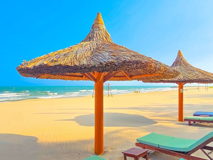 Uma praia privada, espreguiçadeiras, guarda-sóis de praia
