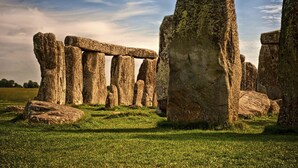 Stonehenge erguido em um campo gramado.