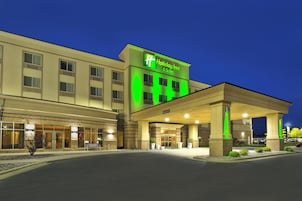 Um Holiday Inn & Suites com entrada acessível, estacionamento e fachada bem iluminada.