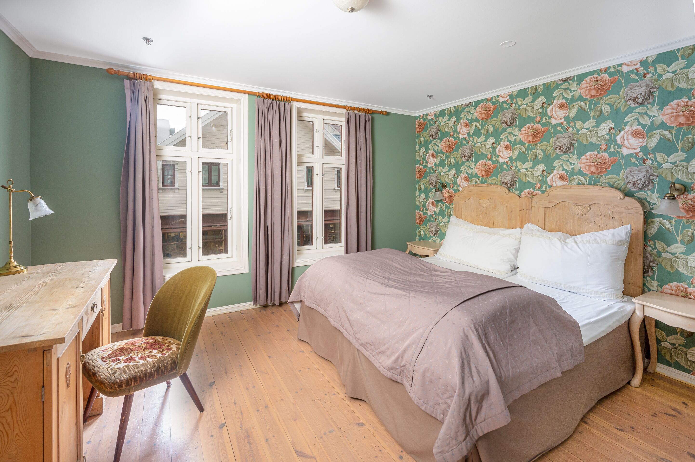 Quarto com uma cama de madeira, uma escrivaninha e uma cadeira.