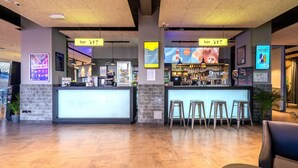 Uma área de bar com banquetas, balcão e quadro de cardápio.