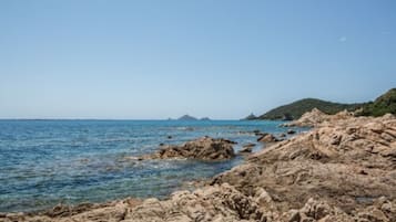 Na praia, espreguiçadeiras, guarda-sóis de praia, toalhas de praia