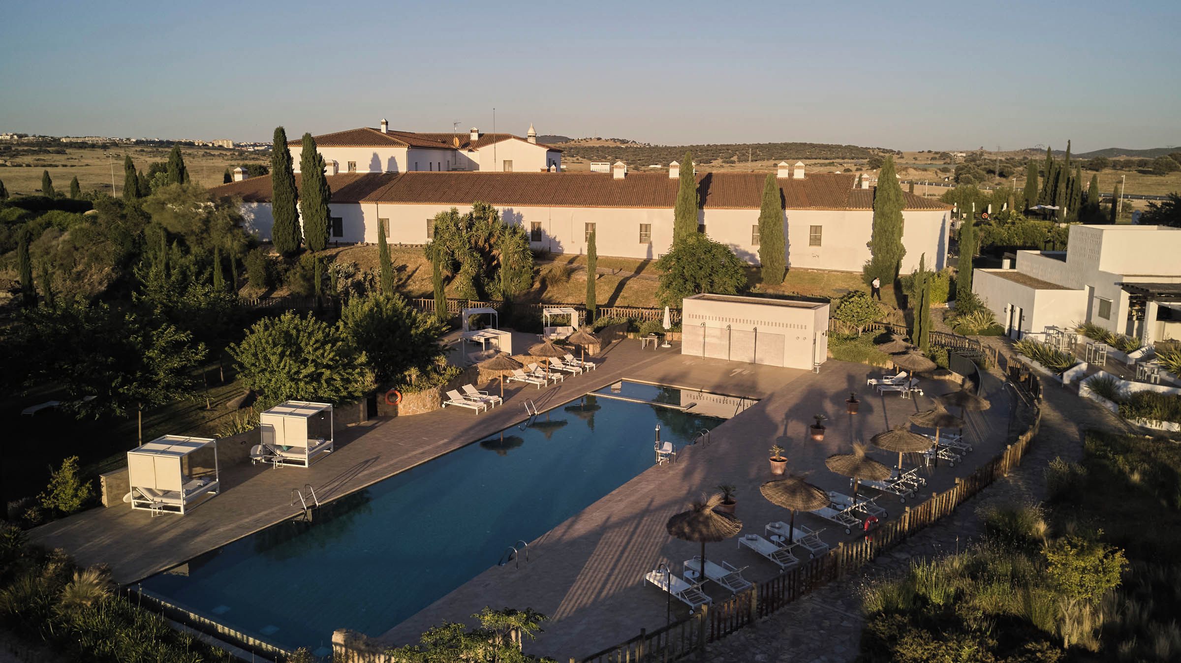 Resort com piscina, espreguiçadeiras e jardim bem cuidado.