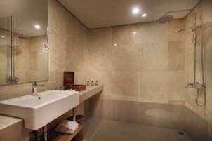 Uma casa de banho moderna com uma grande pia, espelho e chuveiro.