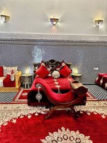 Quarto com cama grande, decoração de parede elaborada e tapetes estampados.