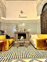 Um quarto com piso estampado, lareira e dois sofás.