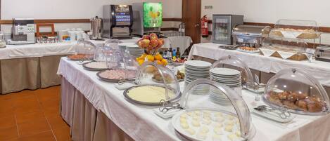 Disposição de buffet com diversos alimentos e um espaço para café.