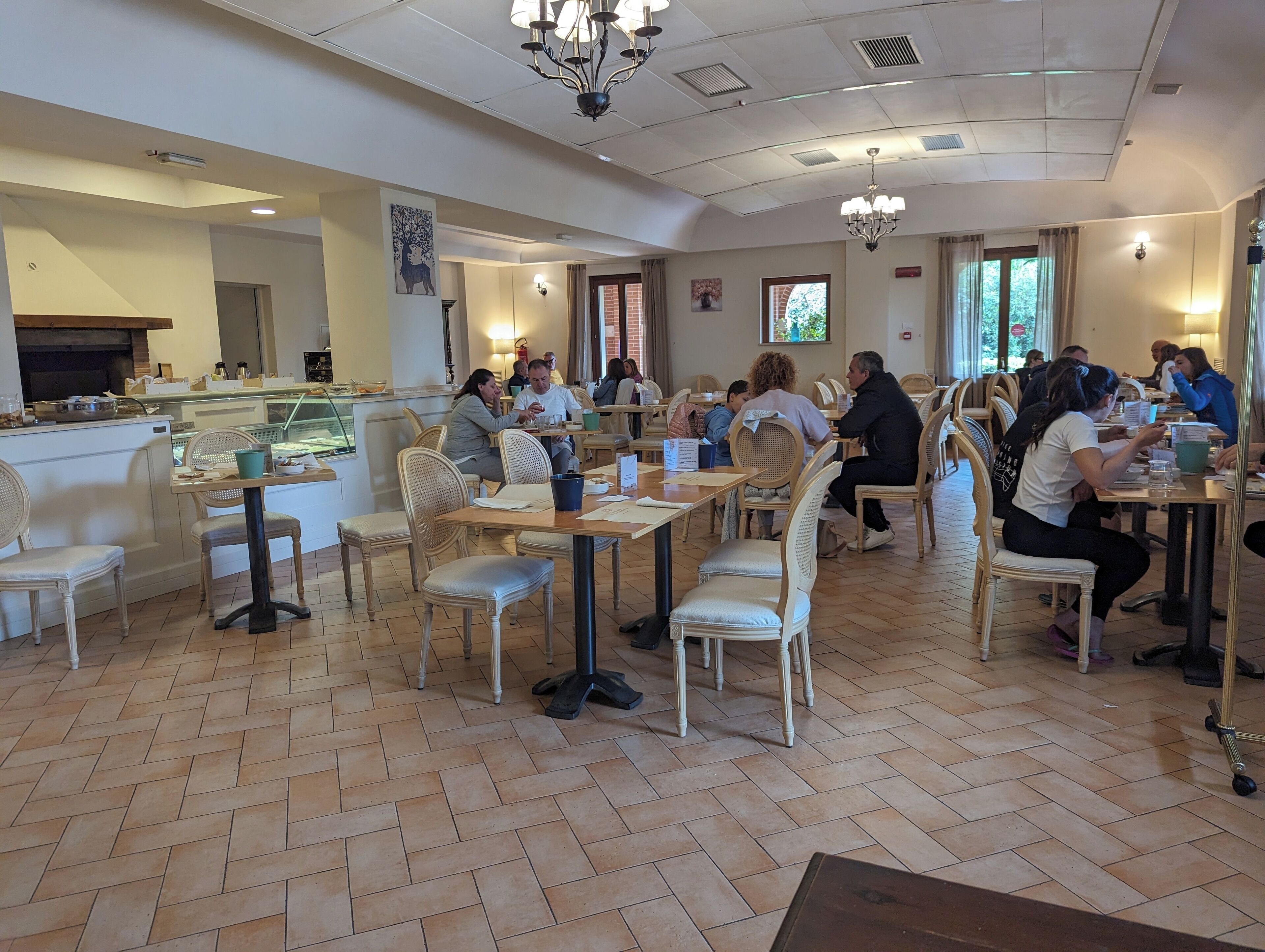Restaurante com piso de madeira, cadeiras de vime e mesas.