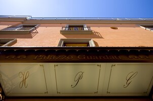 Fachada de edifício com varandas e uma placa com a inscrição 'Palazzo Guardati'.