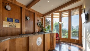 Uma área de recepção com painéis de madeira, um balcão, um relógio e uma placa de boas-vindas aos hóspedes do Days Inn.