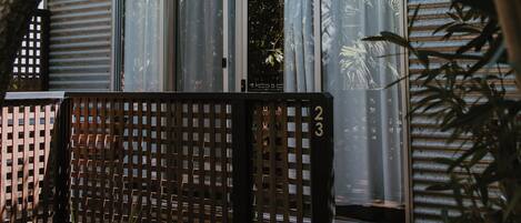 Uma casa com fachada vermelha, janelas amplas e cerca de madeira.