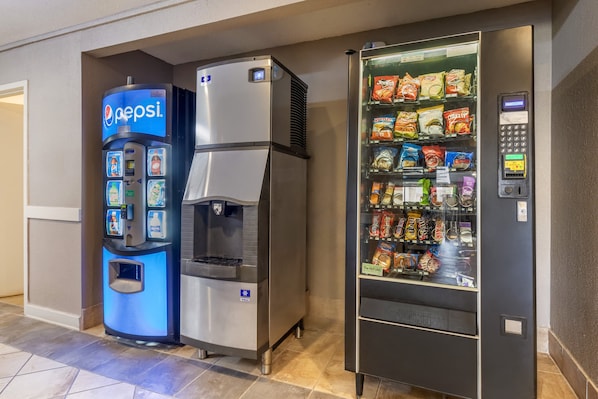 Máquina automática com Pepsi e um expositor refrigerado com lanches.
