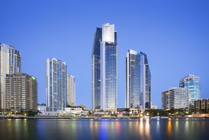 Silhueta urbana com edifícios altos, uma orla marítima e uma ponte.