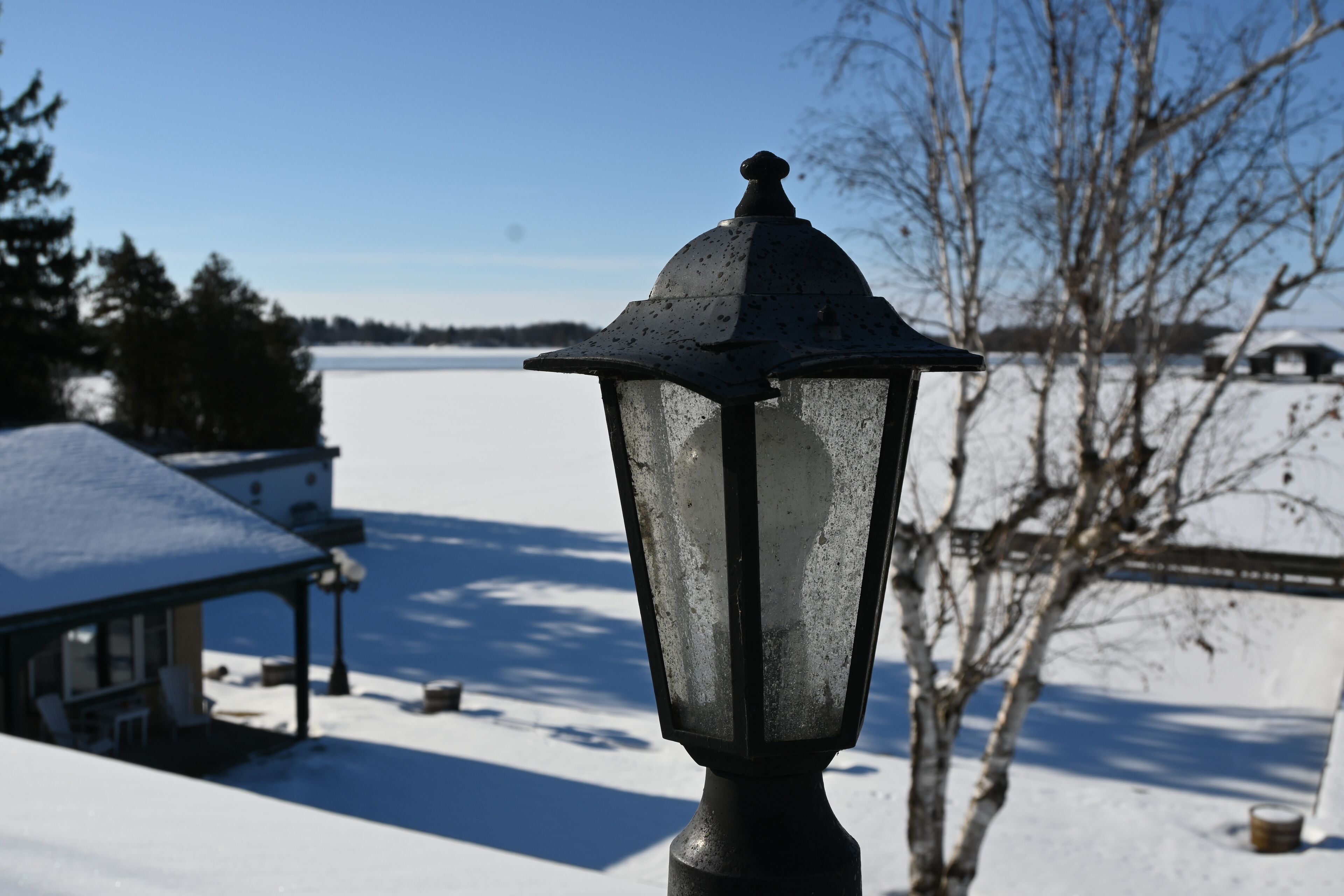 Paisagem coberta de neve com um poste de luz em primeiro plano.