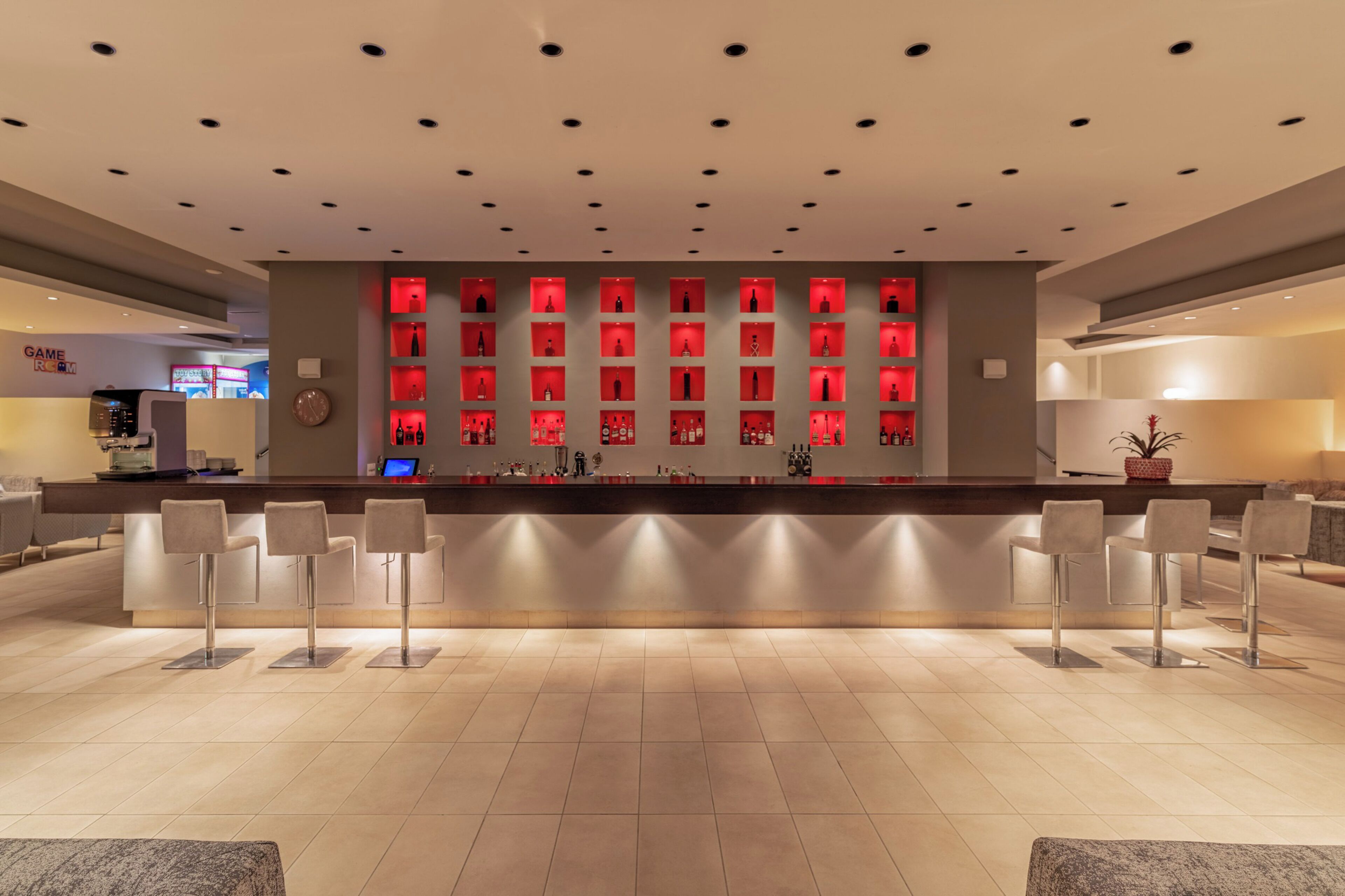 A hotel lobby with a reception desk, bar area, and seating.