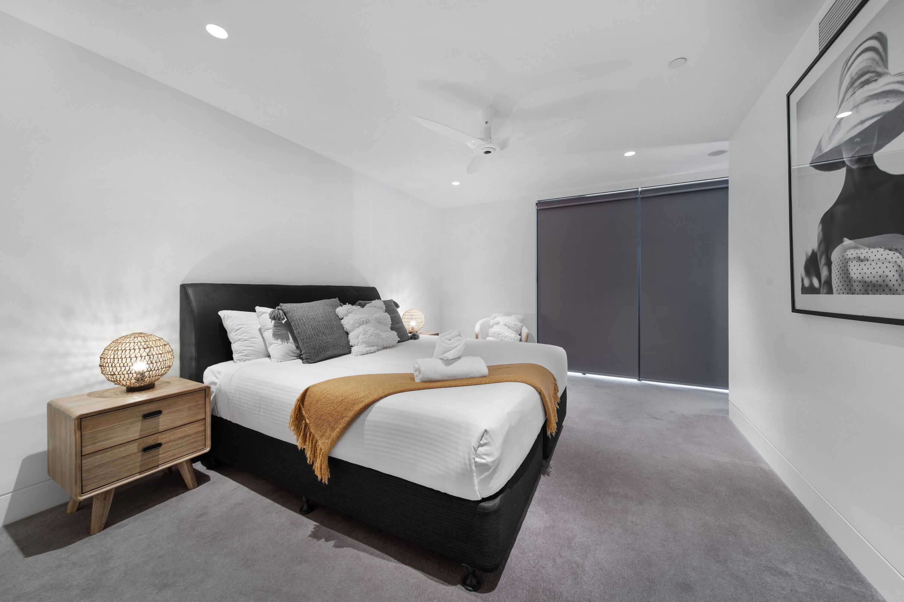 Um quarto moderno com cama, mesa de cabeceira e um guarda-roupa espaçoso.