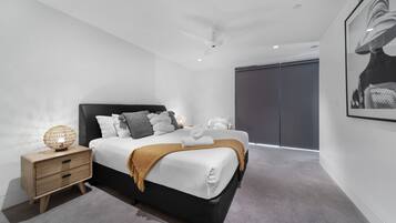 Um quarto moderno com cama, mesa de cabeceira e um guarda-roupa espaçoso.