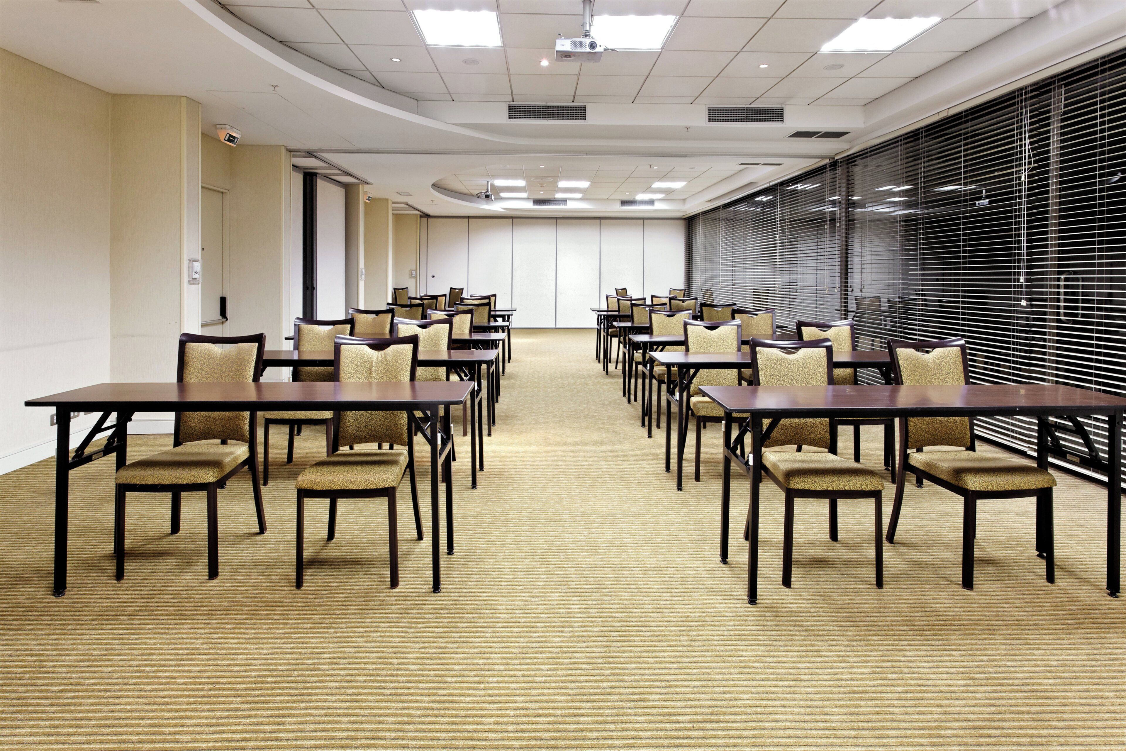 Uma sala de conferências com mesas e cadeiras dispostas para reuniões.