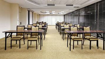 Uma sala de conferências com mesas e cadeiras dispostas para reuniões.