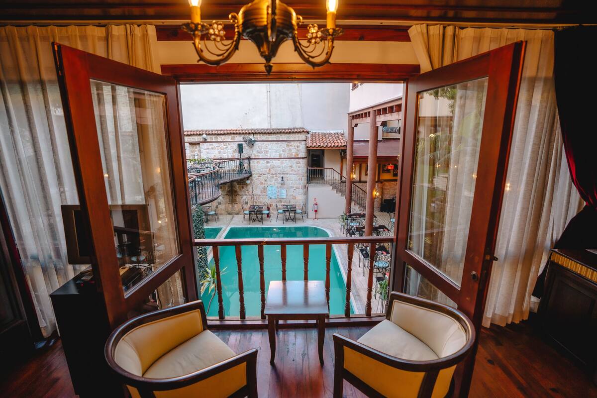 Varanda com vista para uma piscina e área de estar ao ar livre.