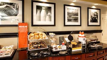 Buffet de café da manhã com diversas opções de comida e um espaço para café.