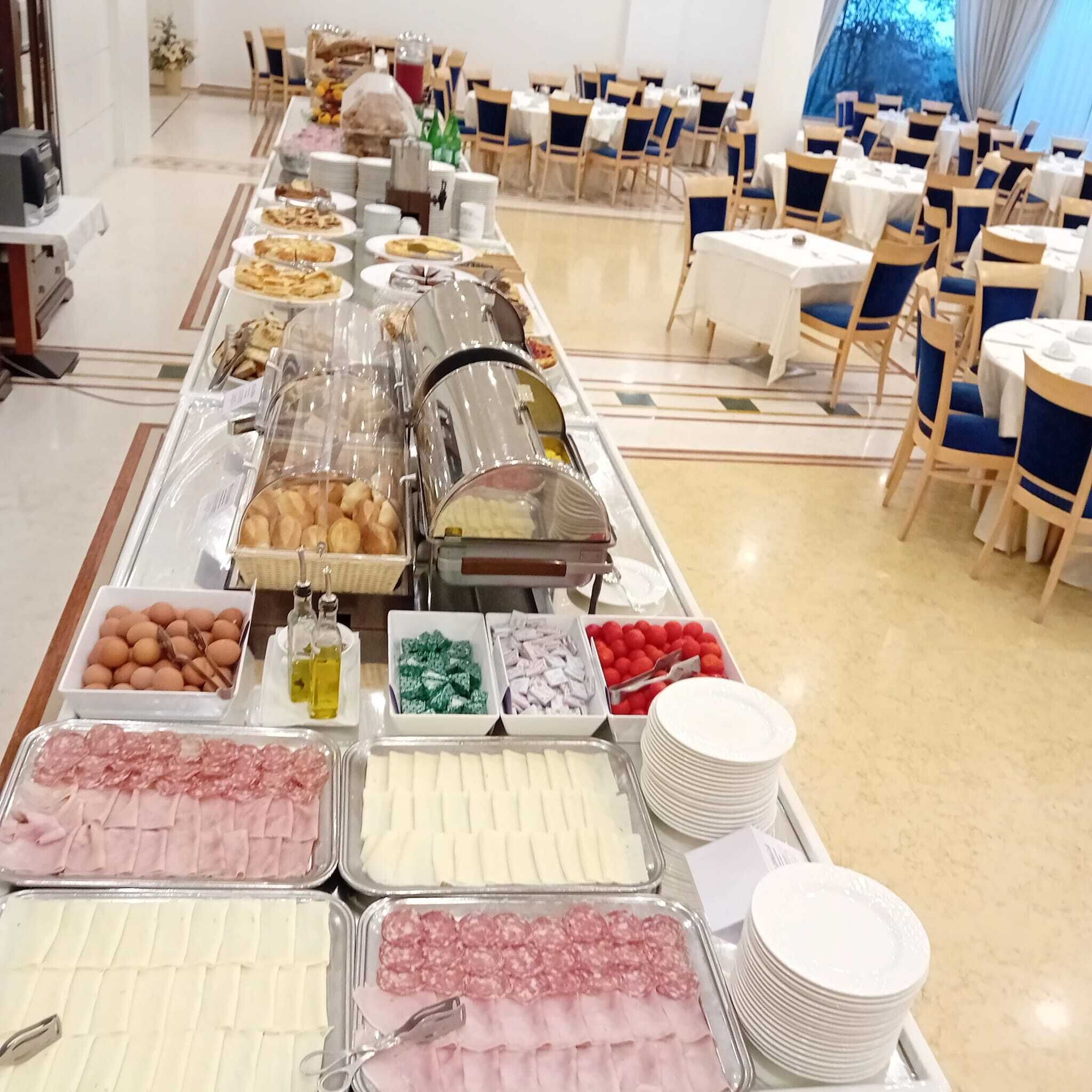 Disposição de buffet com diversos alimentos e utensílios.
