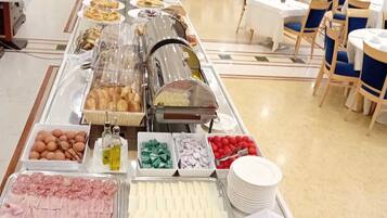 Disposição de buffet com diversos alimentos e utensílios.