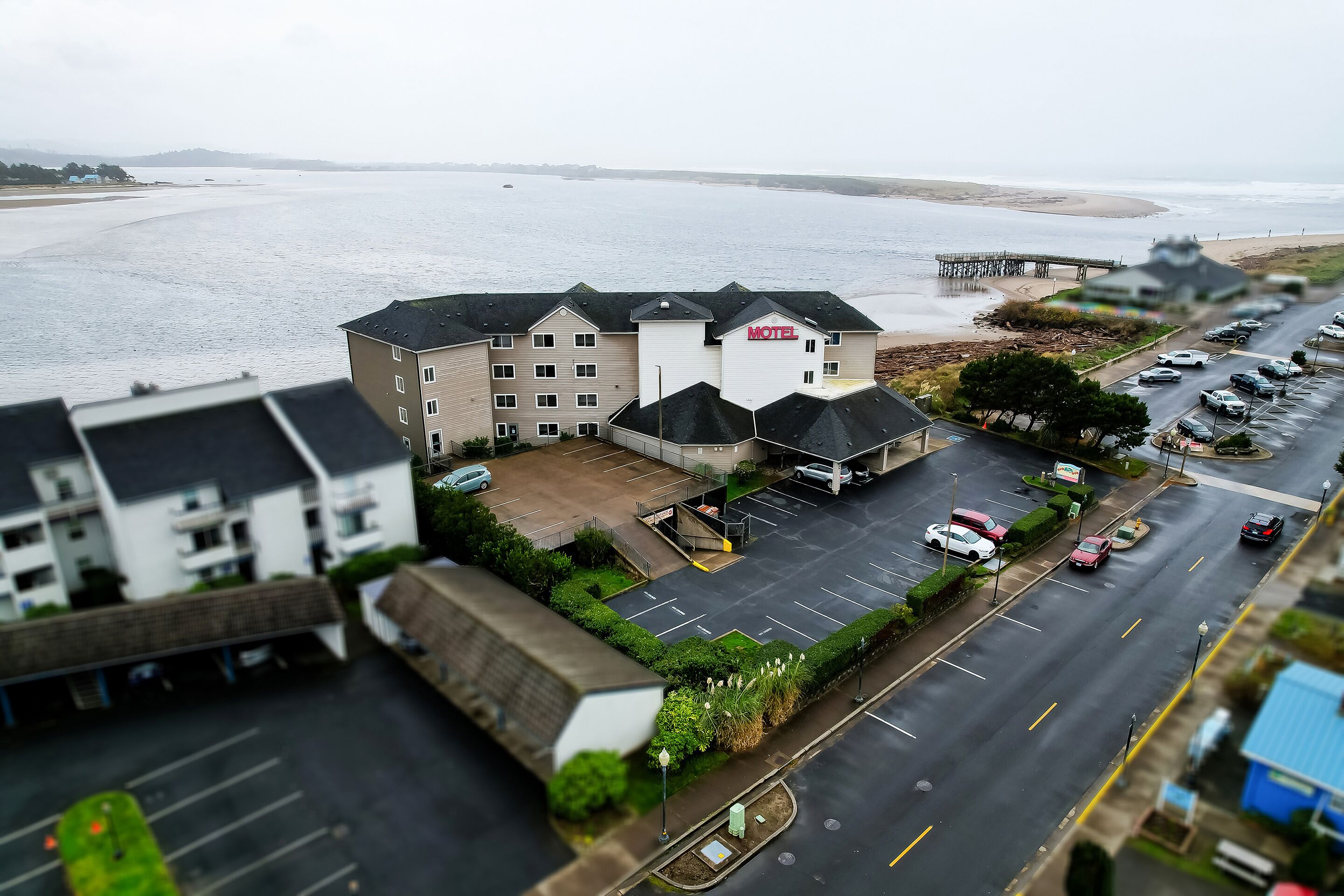 Um motel com estacionamento e vista para a praia.