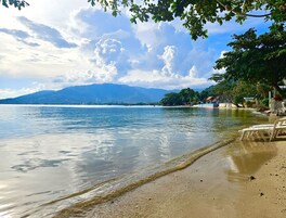 Na praia, praia de areia branca, espreguiçadeiras, guarda-sóis de praia