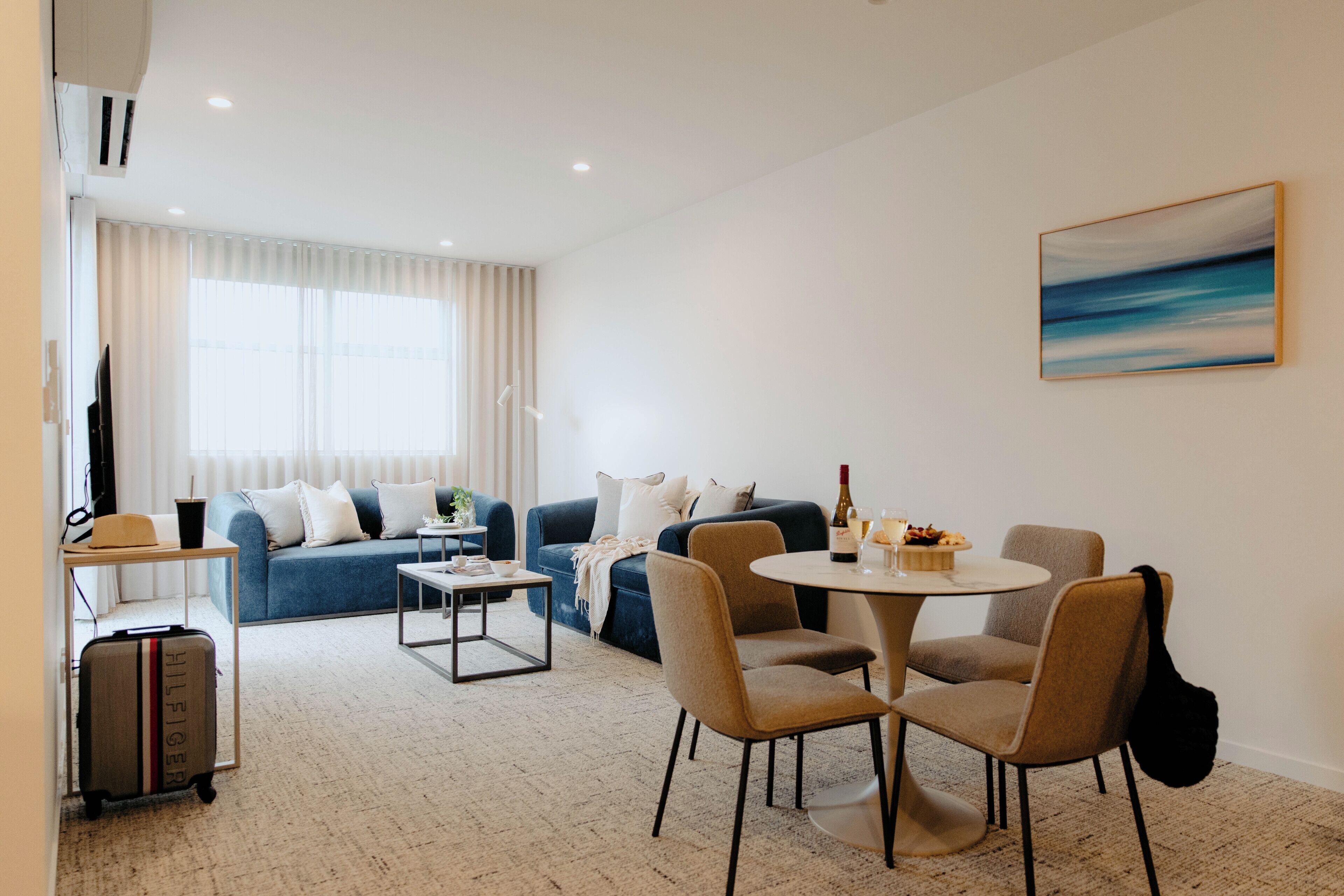 Uma sala de estar moderna com sofá, mesa de jantar e mesa de centro.