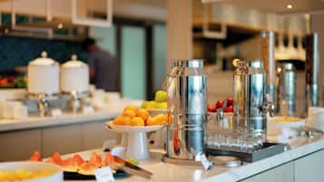 Disposição de buffet com diversos alimentos e dispensadores de bebidas.