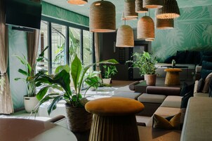Uma área de estar moderna com assentos confortáveis, janelas amplas e luminárias pendentes de fibra.