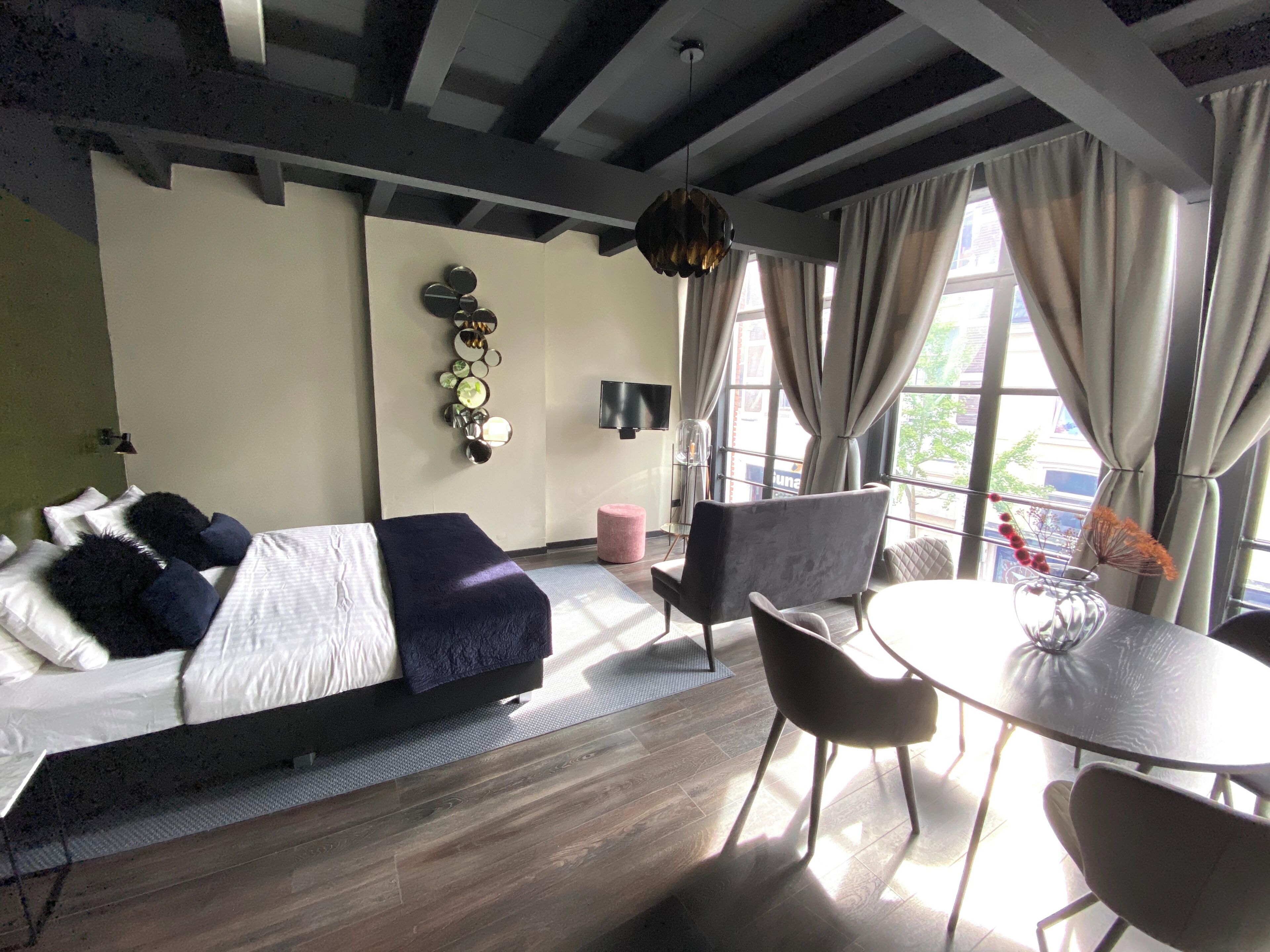 Quarto moderno com uma cama, uma mesa redonda e uma cadeira.