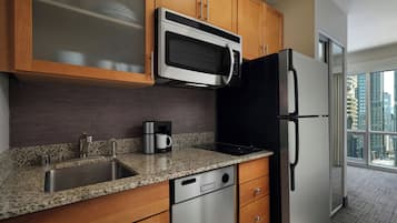Uma cozinha moderna com bancadas de granito, eletrodomésticos de aço inoxidável e armários de madeira.