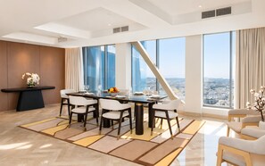 Uma sala de jantar moderna com uma mesa grande, cadeiras e vista para a cidade através de grandes janelas.