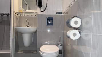 Uma casa de banho moderna com sanita, lavatório e zona de duche.