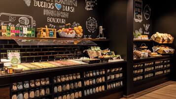 Buffet de café da manhã com diversas opções de comida e uma parede com citações inspiradoras.