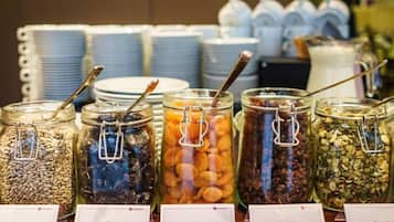 Buffet com potes etiquetados de diversos frutos secos e frutas desidratadas.