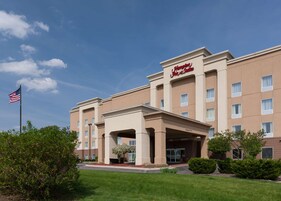 Edifício do Hampton Inn Suites com céu limpo e uma bandeira americana.