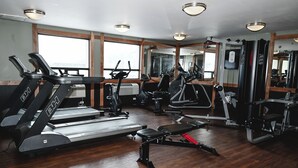 Uma academia com esteiras, elípticos e equipamentos de musculação.
