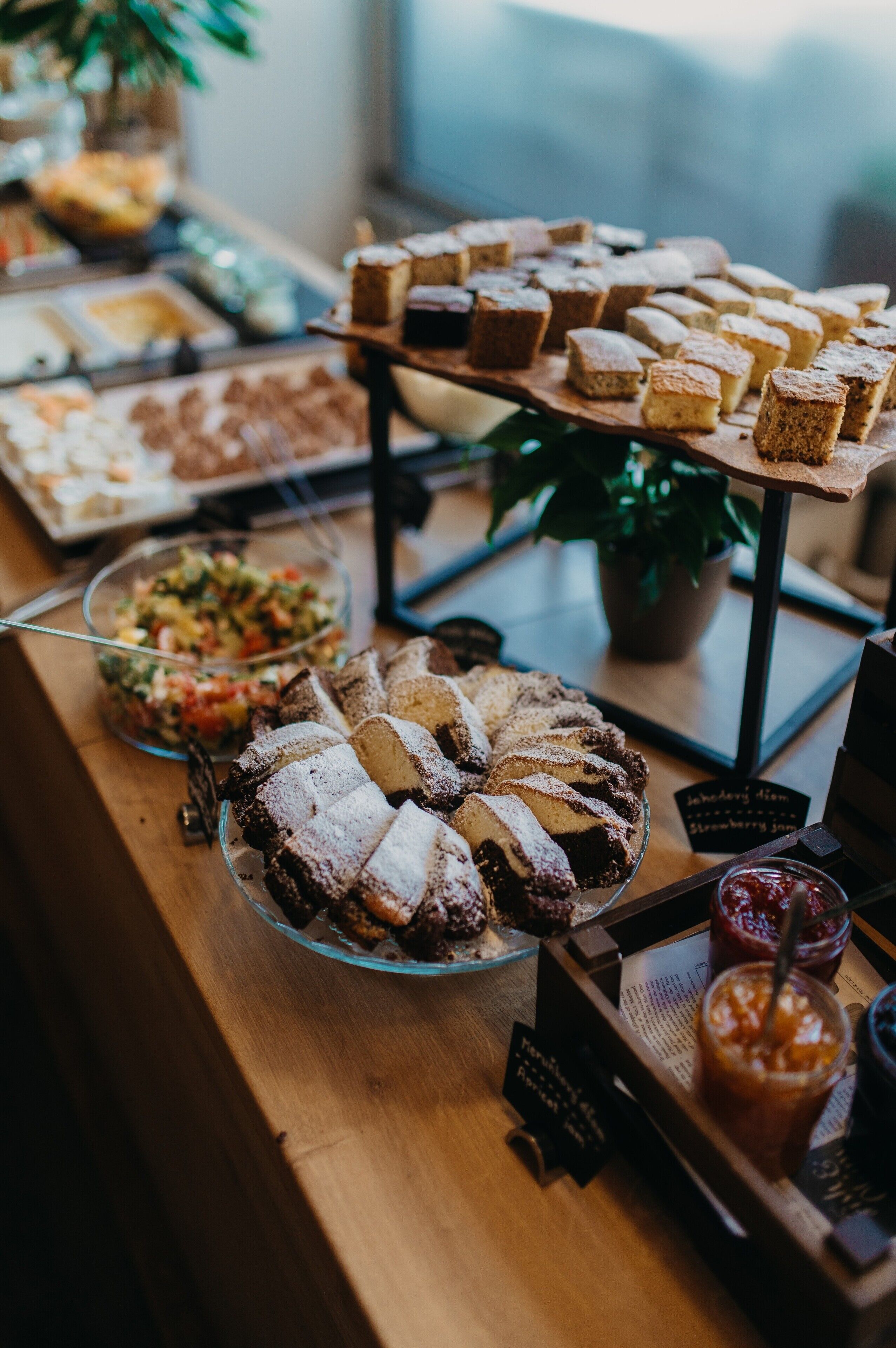 Mesa de buffet com diversos doces e uma saladeira.