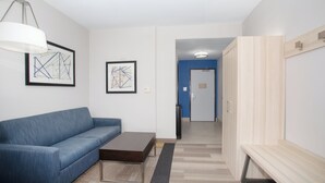 Uma sala de estar moderna com um sofá azul, uma mesa de centro e arte abstrata nas paredes.