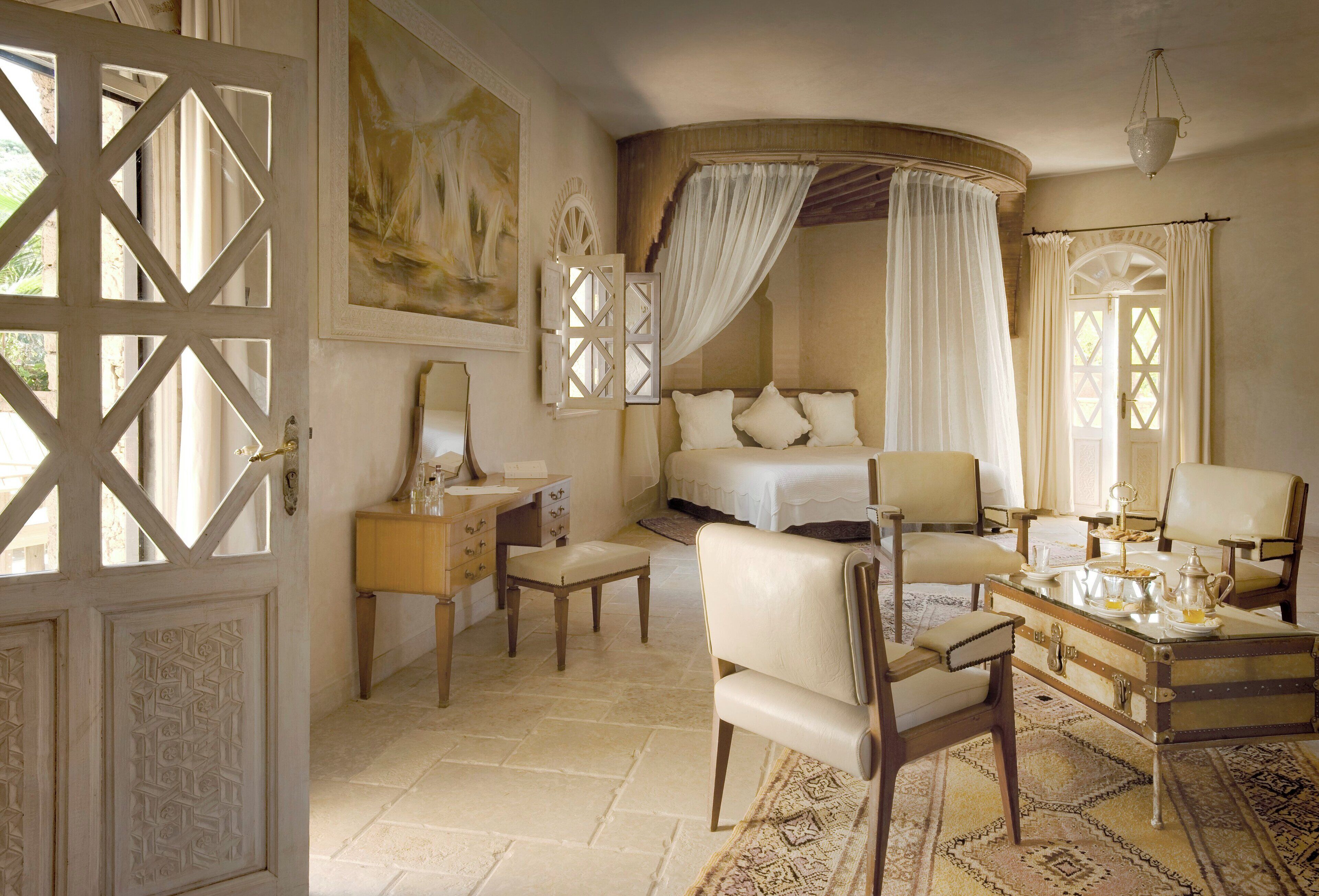 Quarto com cama, escrivaninha, cadeira e mesa de cabeceira.