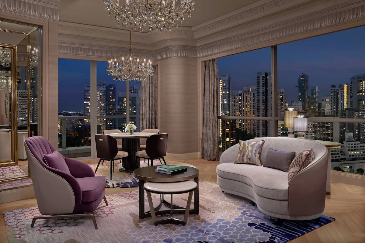 Uma sala de estar ampla com uma grande janela com vista para a paisagem urbana à noite.