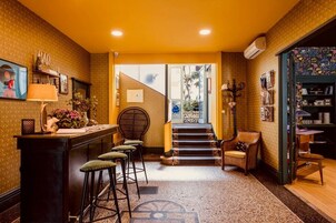 Um interior acolhedor com área de bar, escada e estante de livros.