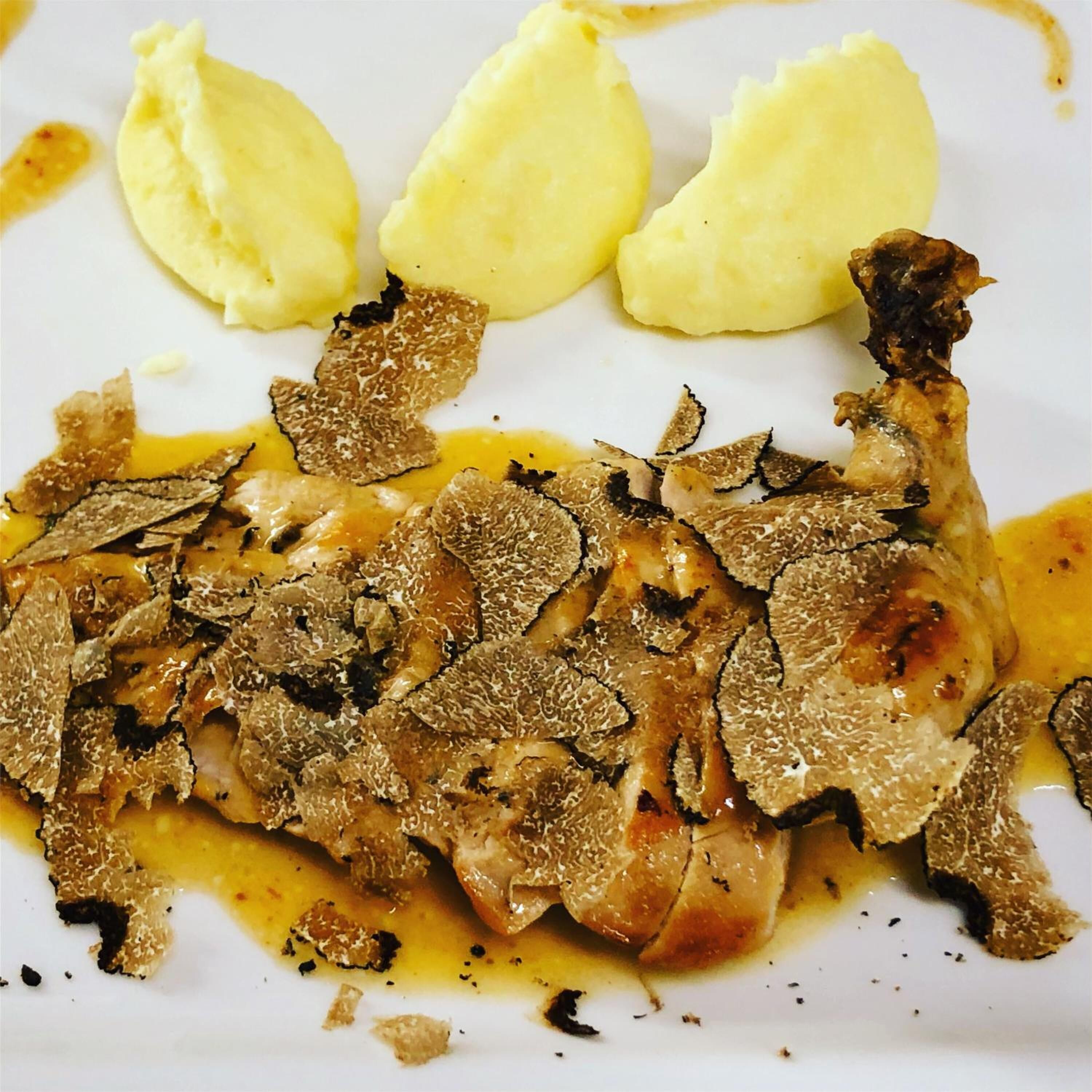 Prato com carne coberta por lascas crocantes, acompanhado de purê de batatas.