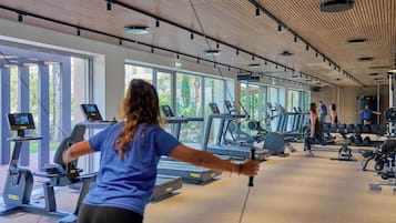 Uma academia com esteiras, bicicletas ergométricas e aparelhos de musculação.