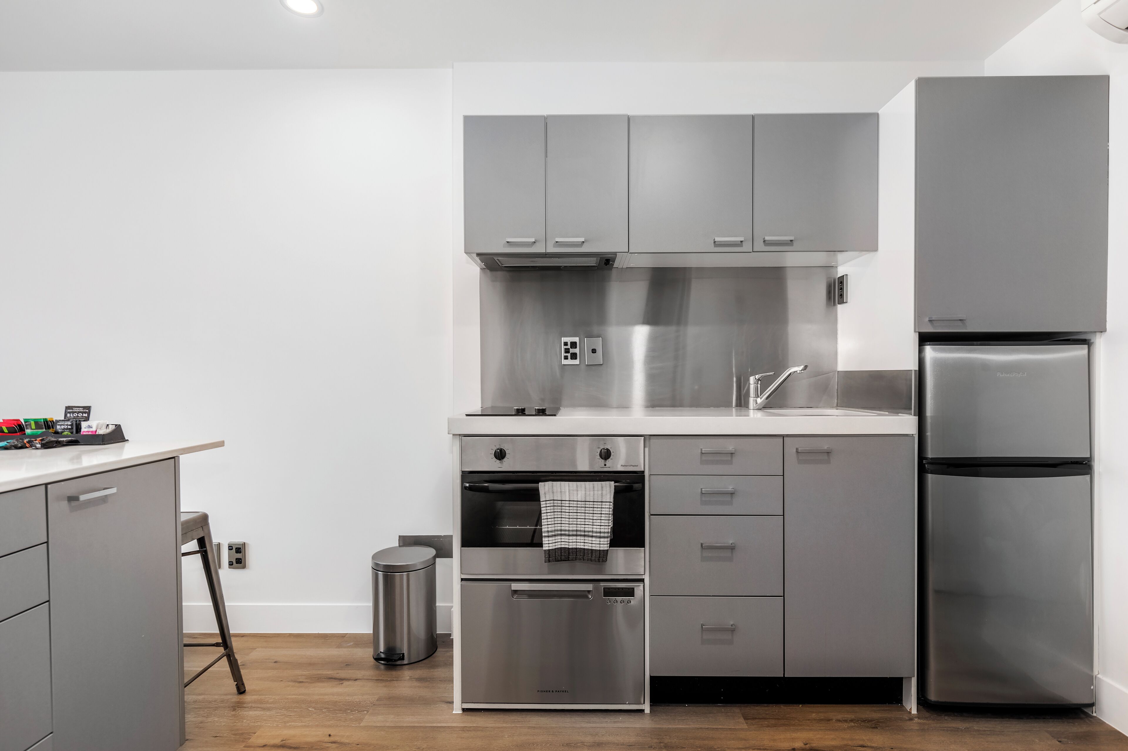 Uma cozinha moderna com eletrodomésticos de aço inoxidável, forno embutido e geladeira.