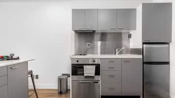 Uma cozinha moderna com eletrodomésticos de aço inoxidável, forno embutido e geladeira.